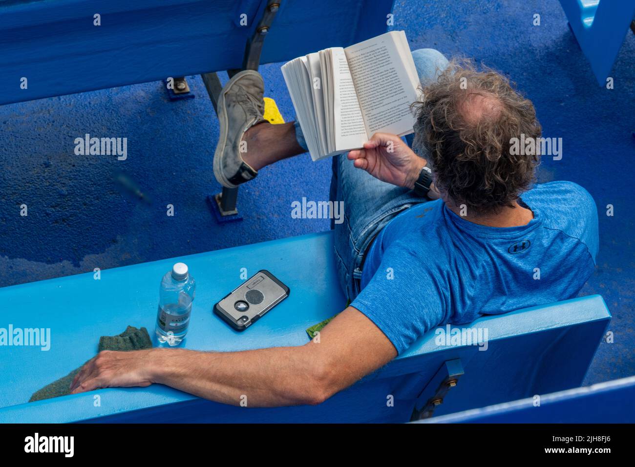 man sitting on bench reading book, man on summer holidays, male ...