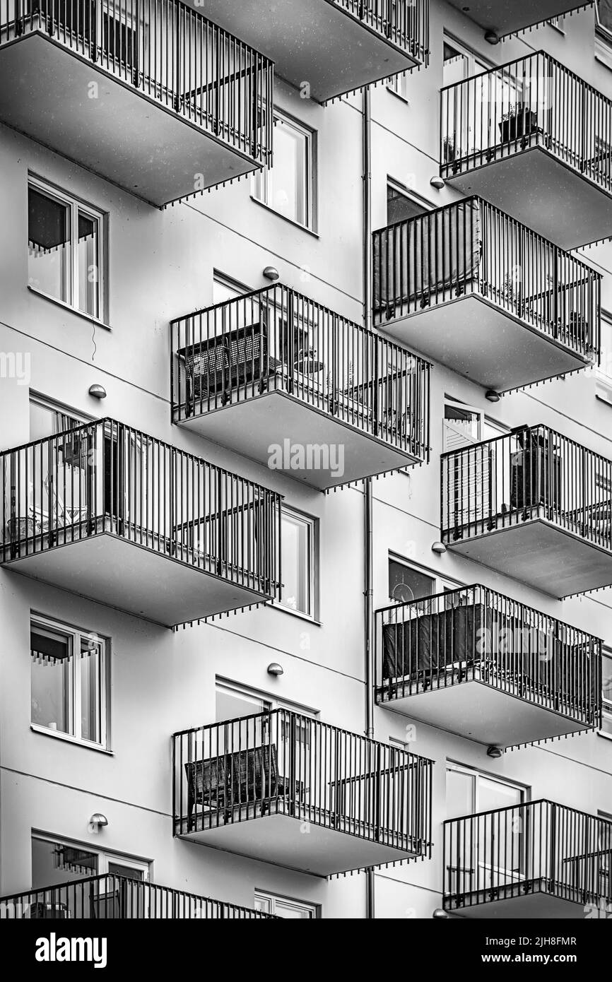 A vertical grayscale of a residential building with balconies in the ...