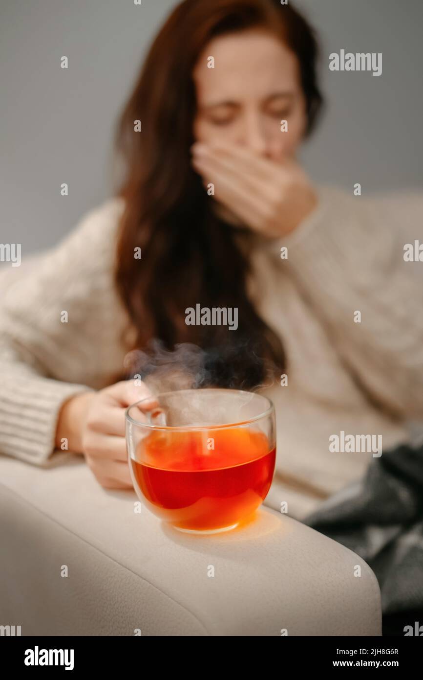 A mug of hot tea for colds and flu keeps the woman sick Stock Photo - Alamy