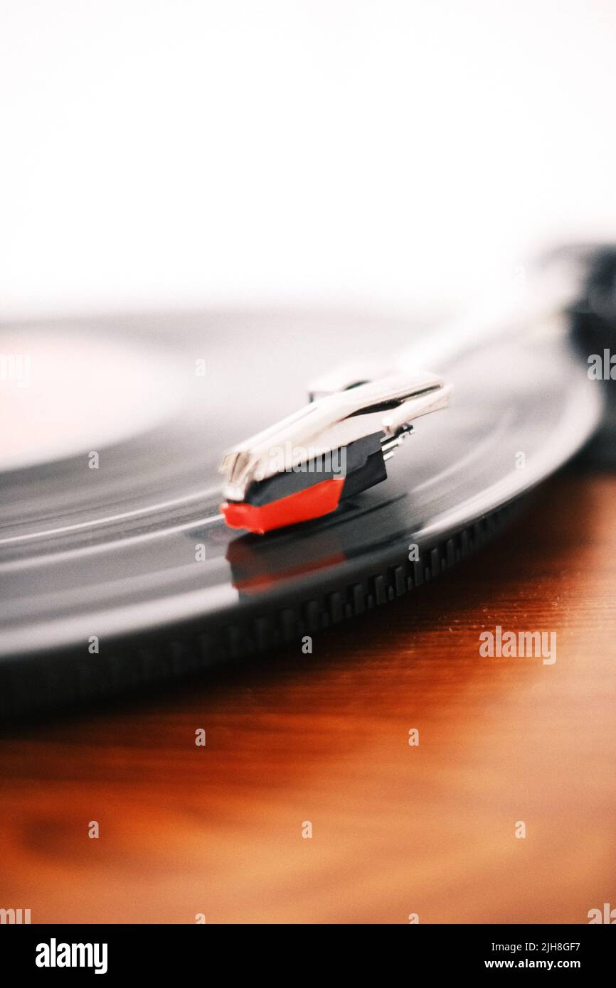 The vertical view of a vinyl disc playing on the wooden retro record ...