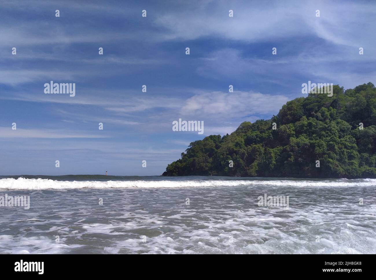 A beautiful shot of waves coming onto a white sandy beach shore during ...