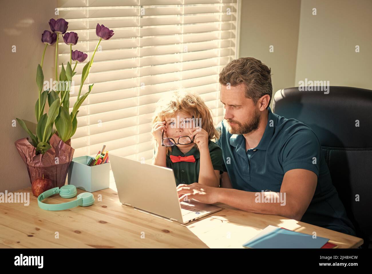 busy dad helping his school son child in glasses study with computer at home, nerd Stock Photo ...