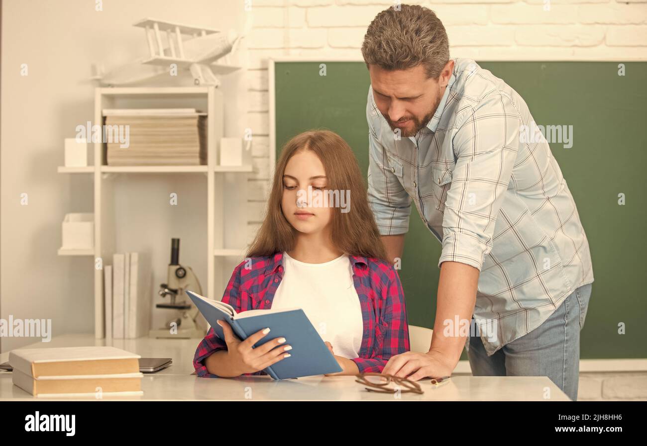 curious father and child study at school with book on blackboard ...