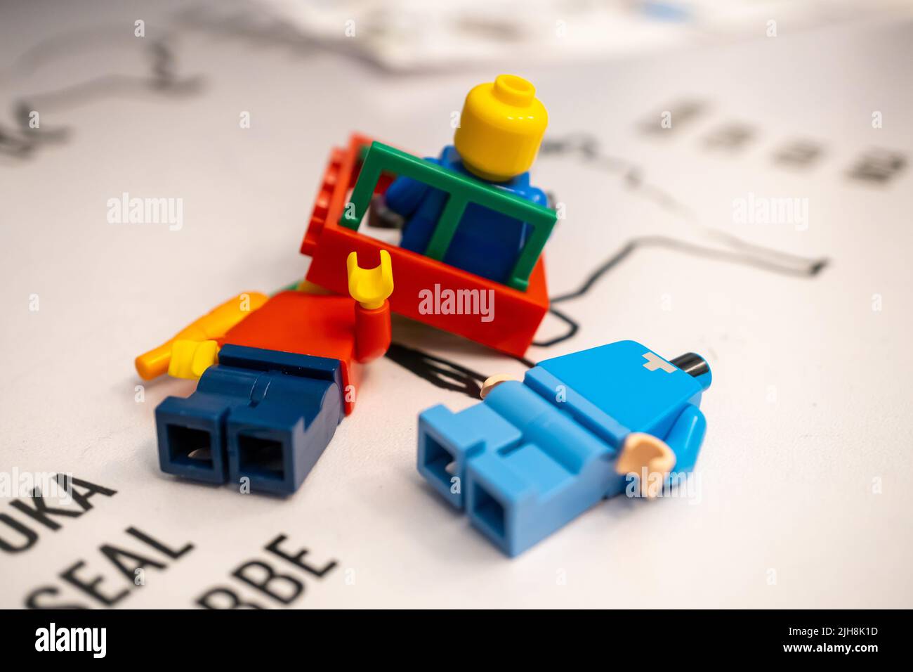 A close-up shot of Lego toy figurine pieces and a window laying on a ...