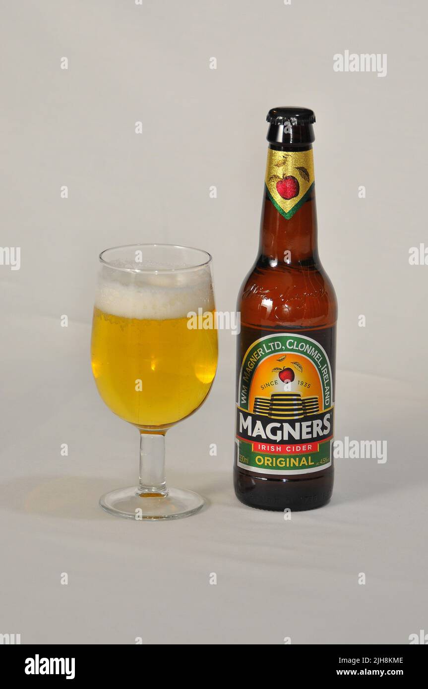 A vertical shot of a bottle and a cup of Magners beer in a studio Stock ...