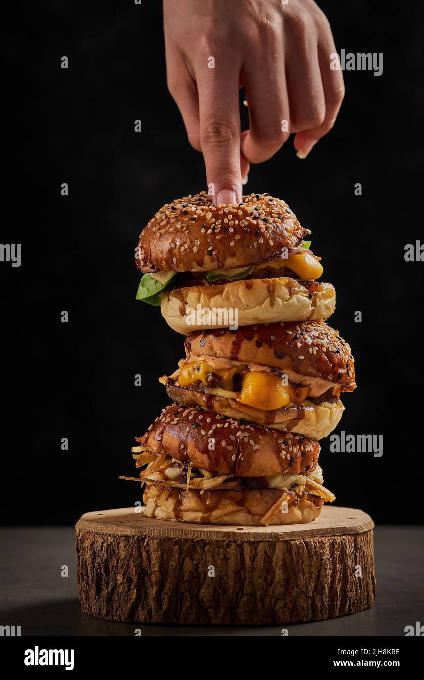 A studio shot of a mouthwatering triple cheeseburger with melted cheese ...