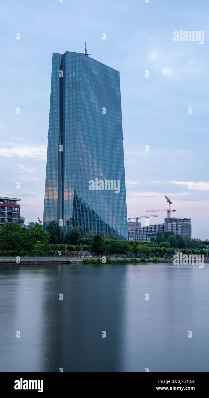 A vertical shot of a modern skyscraper with a glass building on the ...