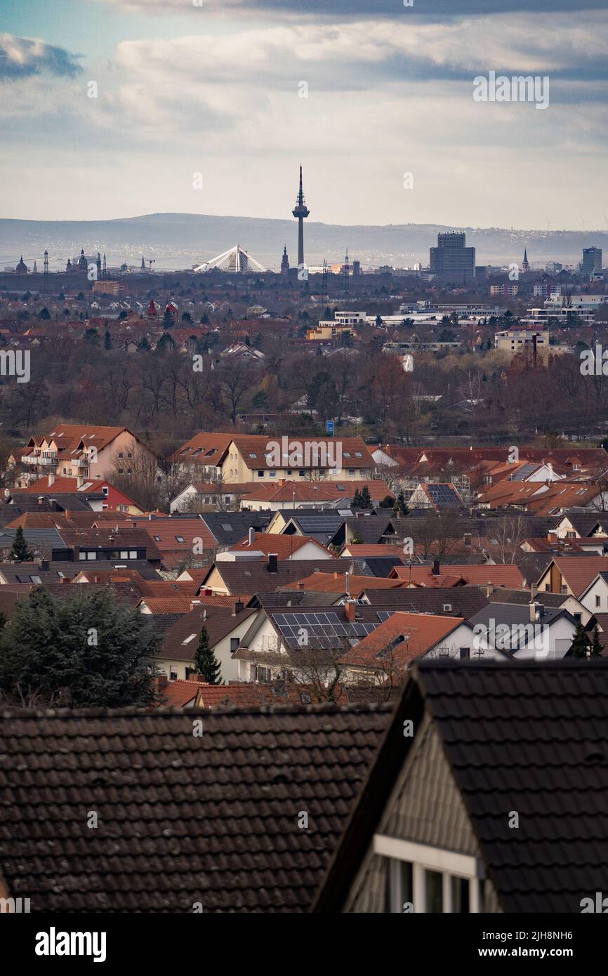 A vertical shot of a cityscape with beautiful rooftops and a tall tower ...