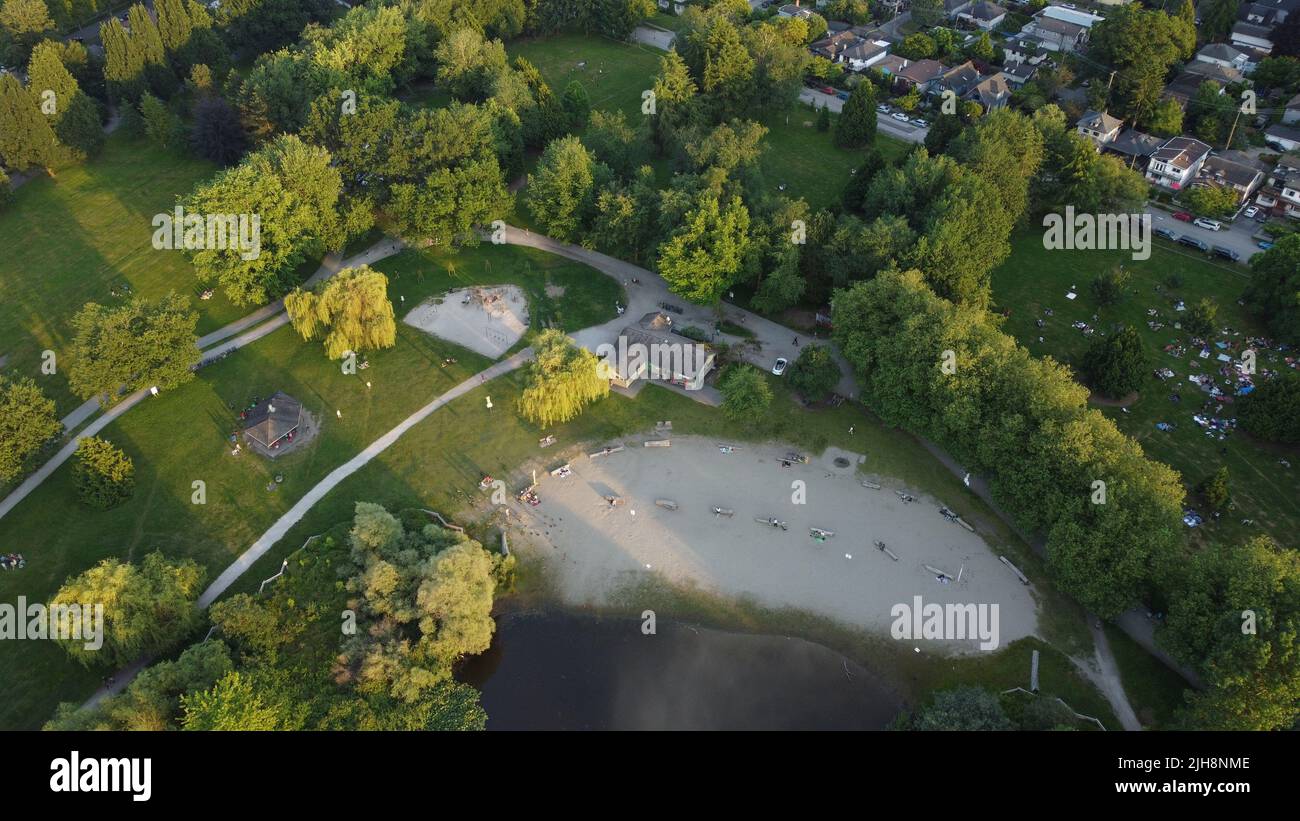 The aerial top view of a park surrounded by trees and city buildings ...