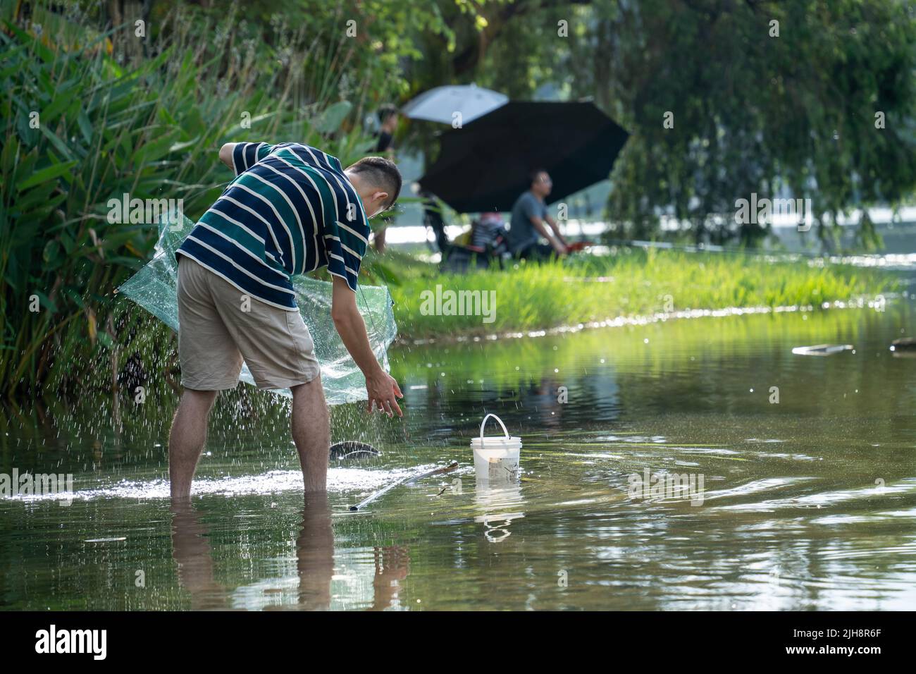 Man taking fish out water hi-res stock photography and images - Alamy