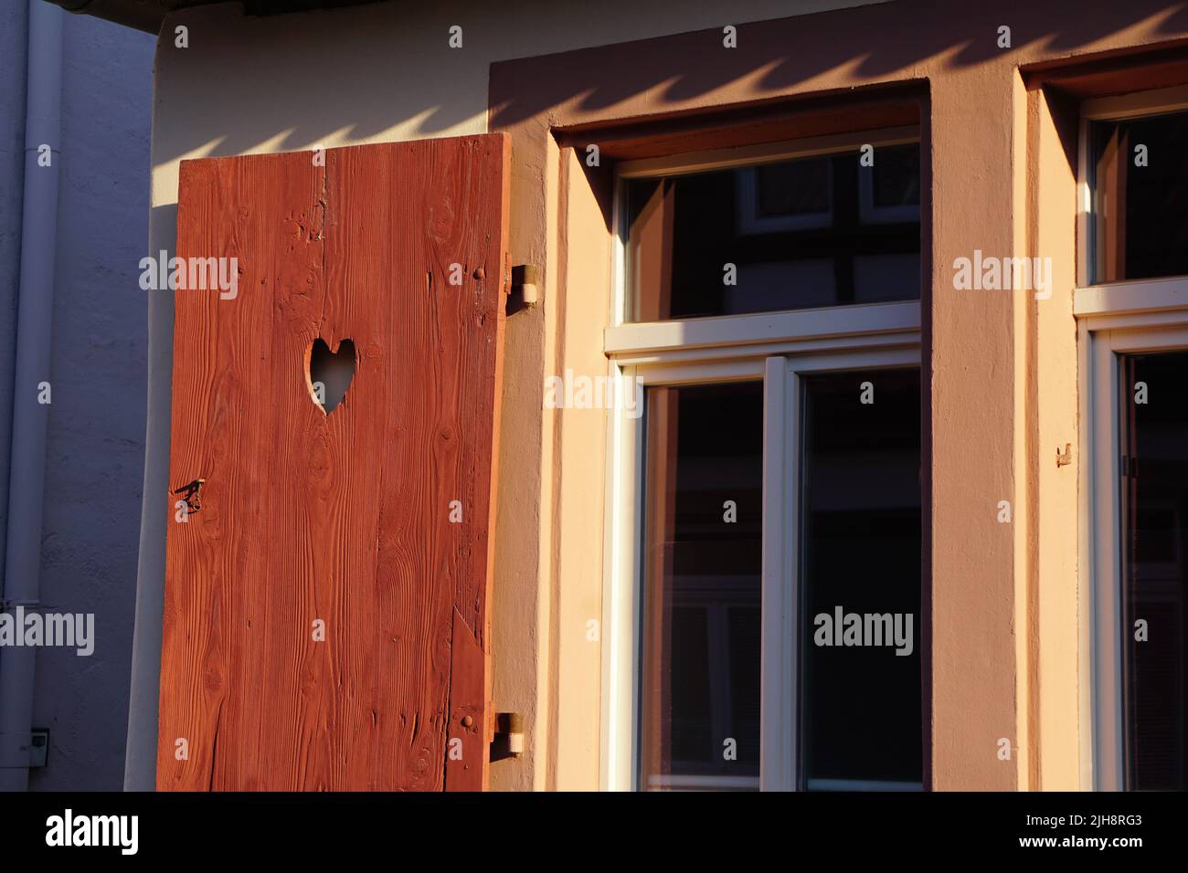 The white windows of a building with heart-shaped hole on the wooden ...
