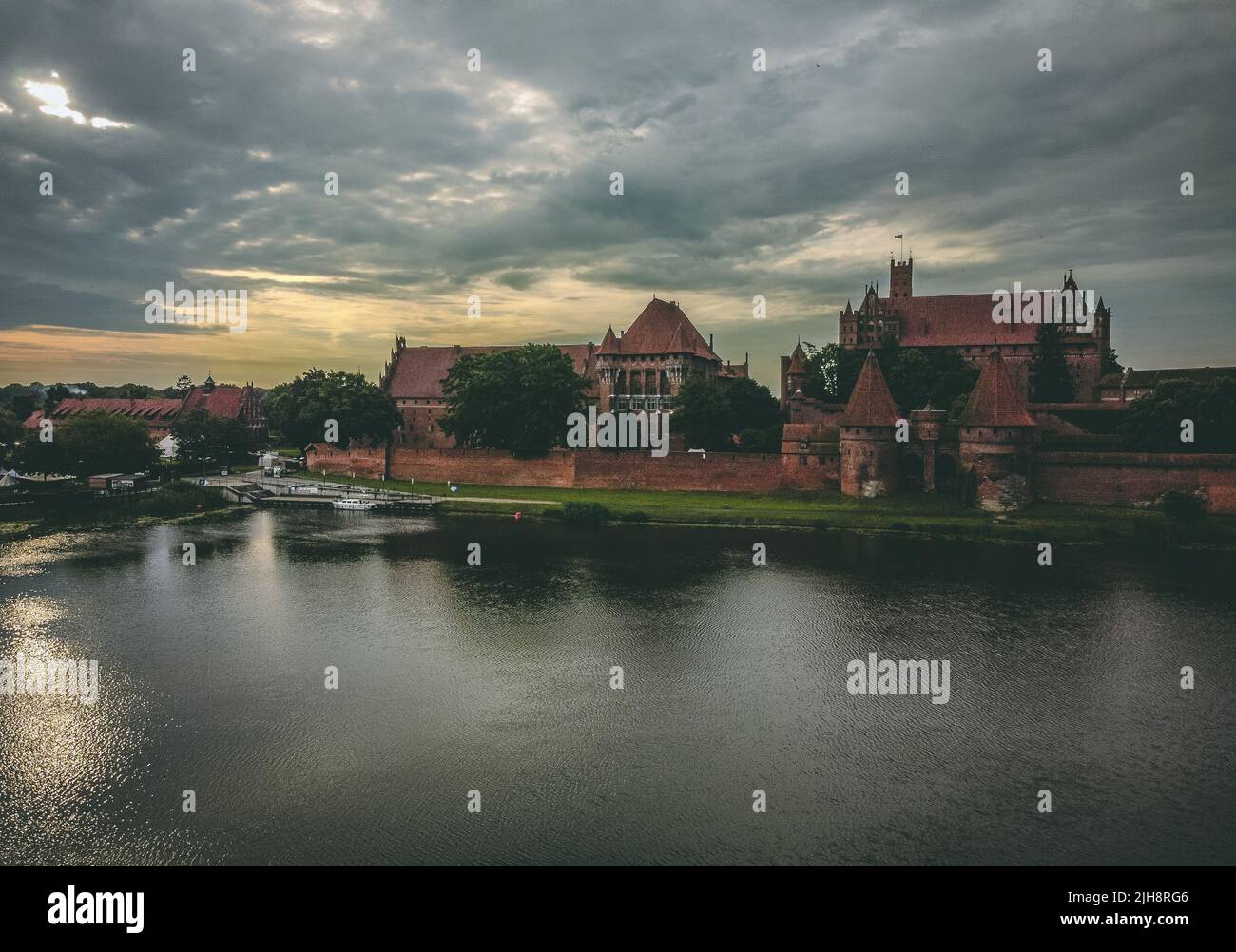 A beautiful view of Malbork Castle from across the Nogat with a cloudy ...