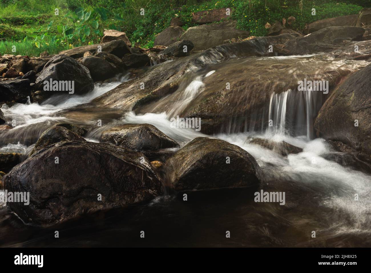Long shutter shot of a small waterfall showing the movement of water ...