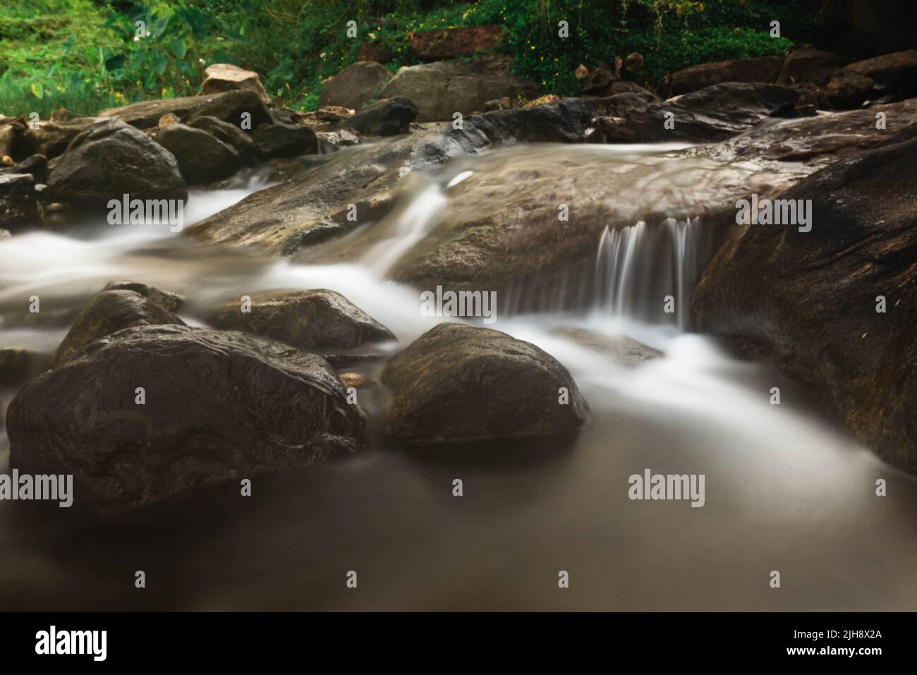 Long shutter shot of a small waterfall showing the movement of water ...