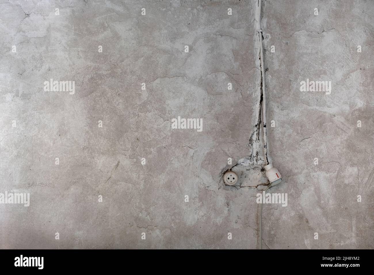 Rustic electrical socket on old limewashed plaster wall, indoor ...