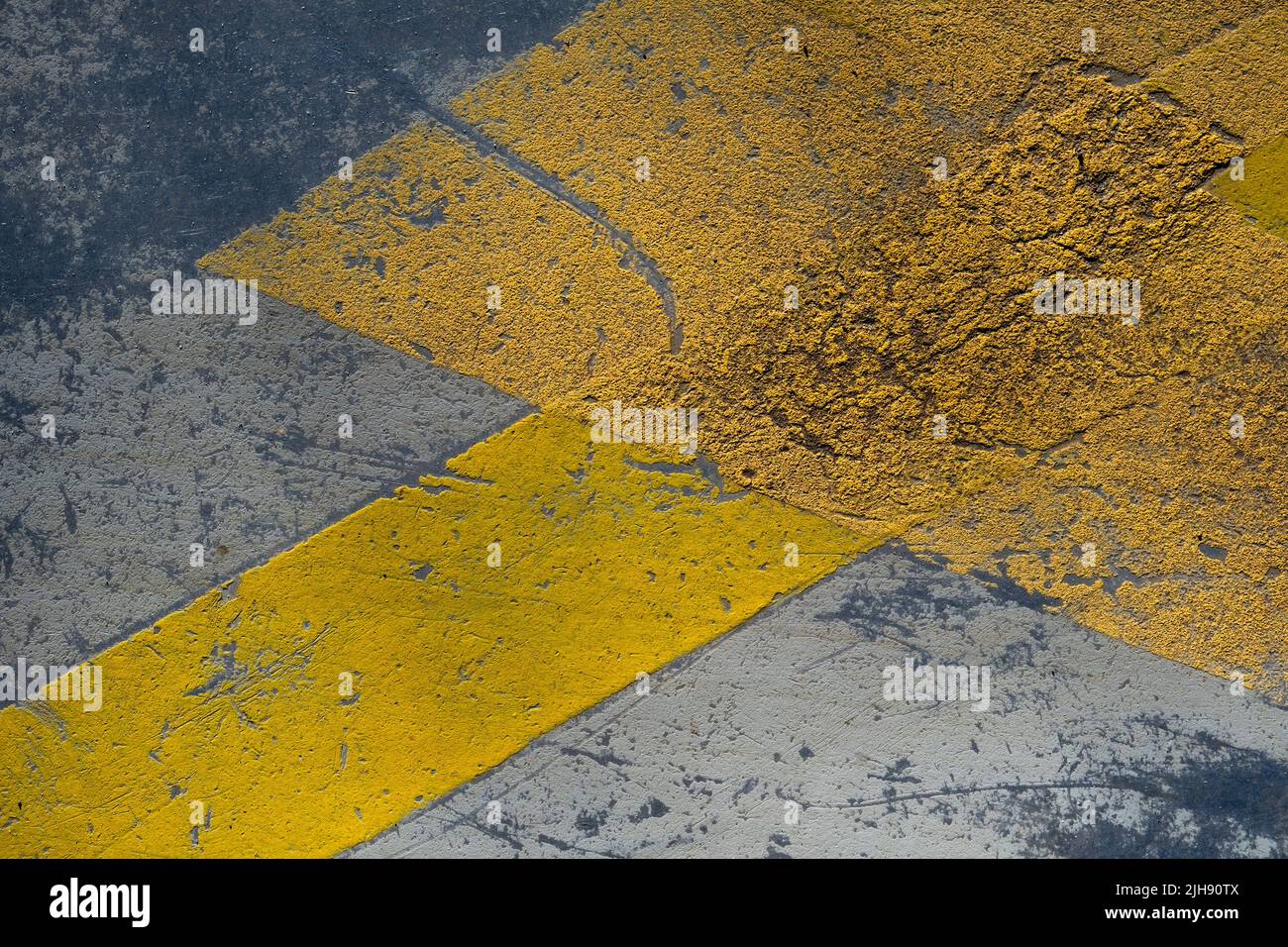 Reflective yellow bands painted on a parking lot pavement, road grunge ...