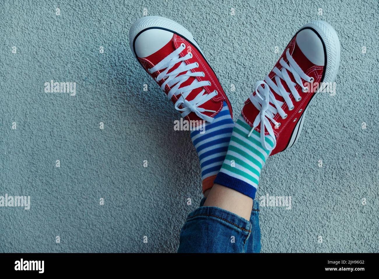 Kid wearing different pair of socks. Child legs up in mismatched socks ...