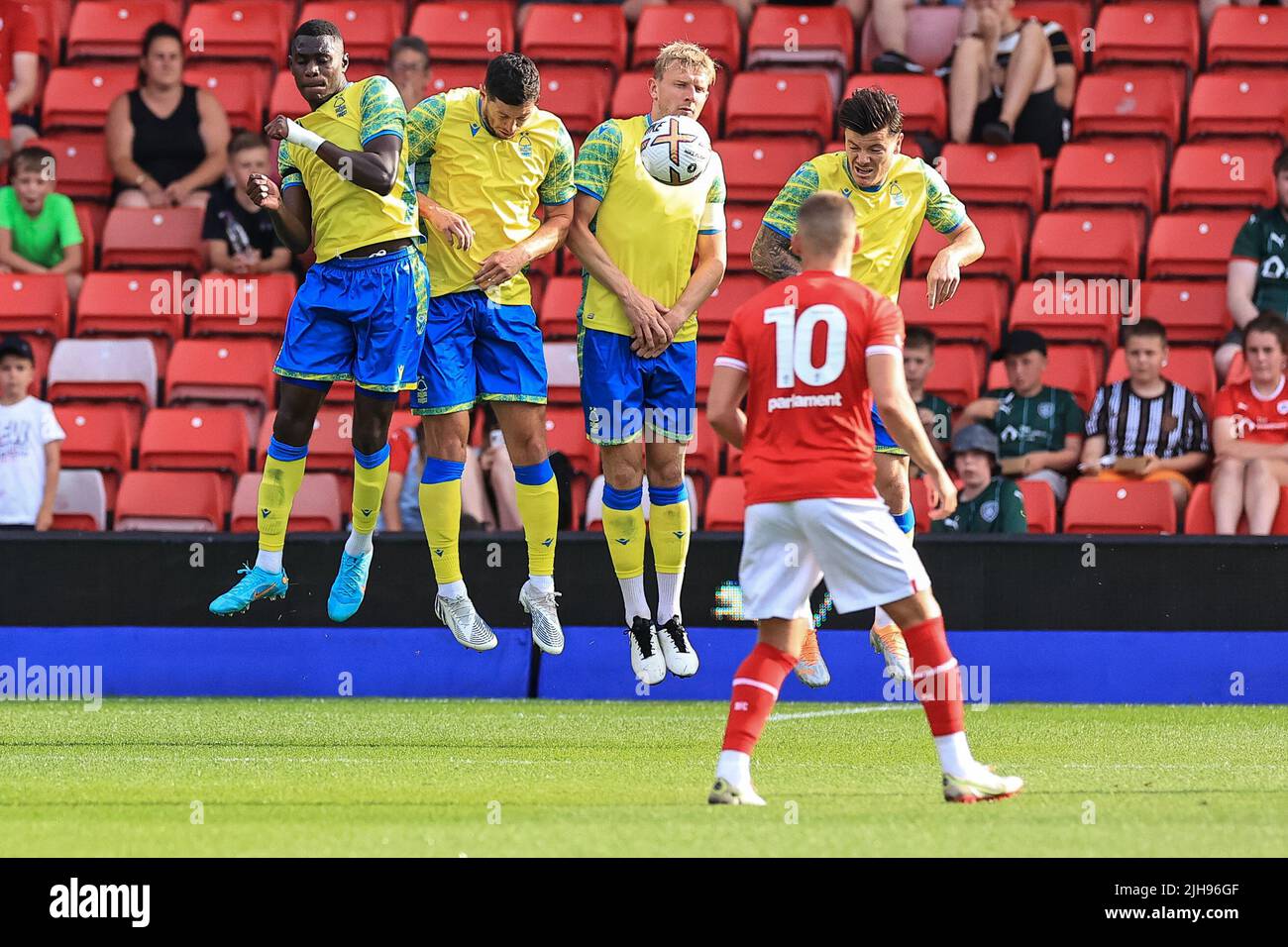 Josh Benson #10 of Barnsley bounces his free kick off a Forest wall ...