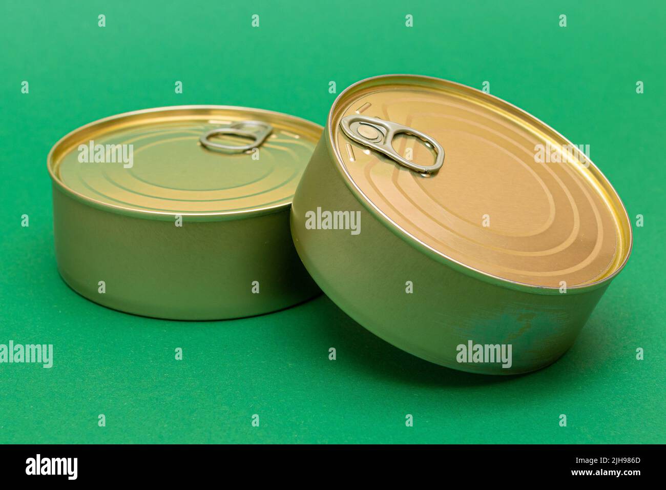 A Group of Stacked Tin Cans with Blank Edges on Green Background ...