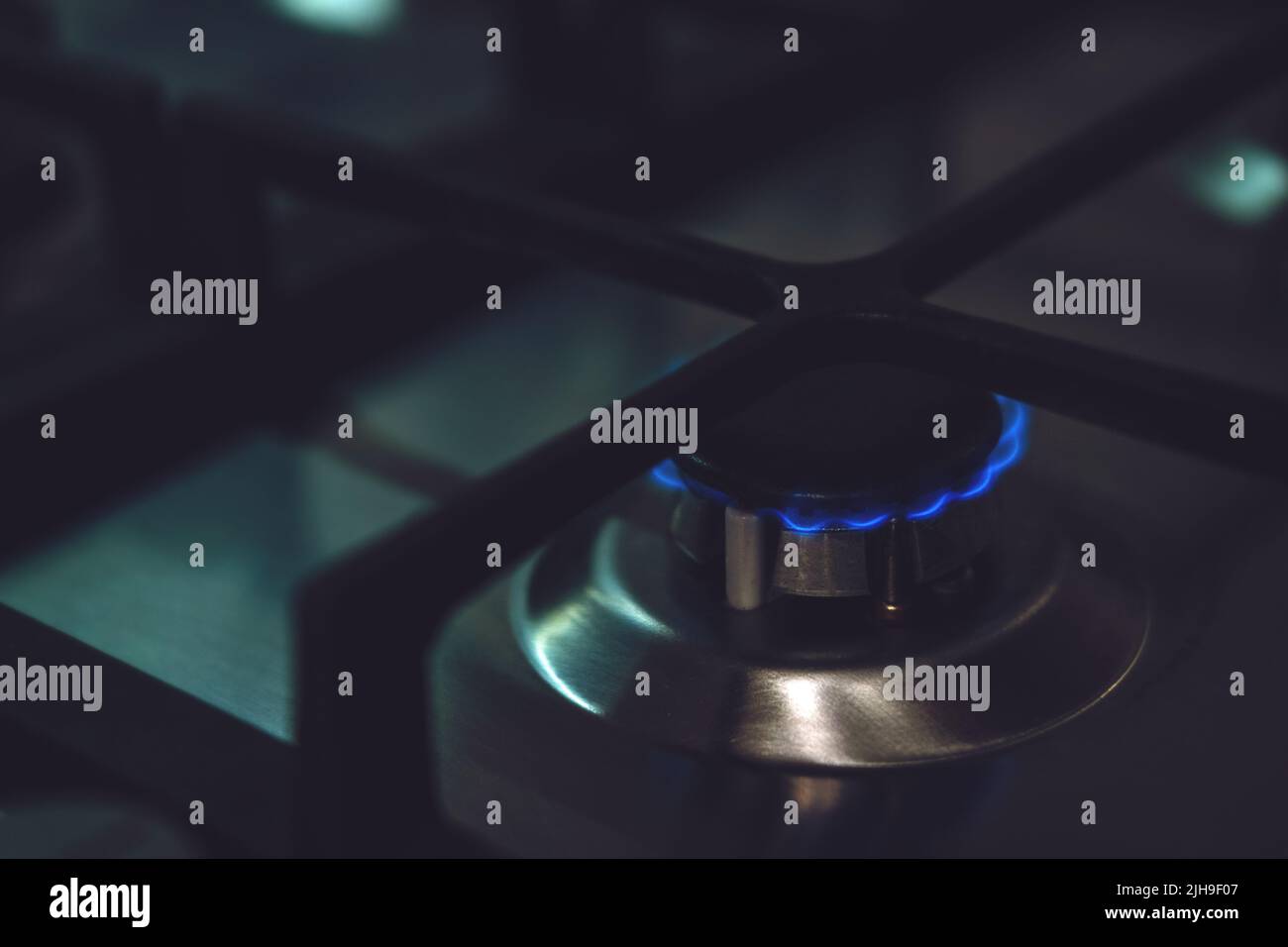 Closeup of blue gas flame on domestic kitchen stove. Gas cooker with ...
