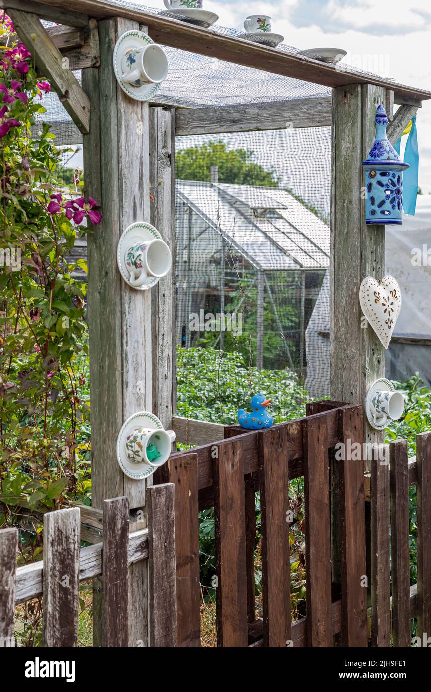 Doorway with a wooden gate to an allotment with cups and saucers ...