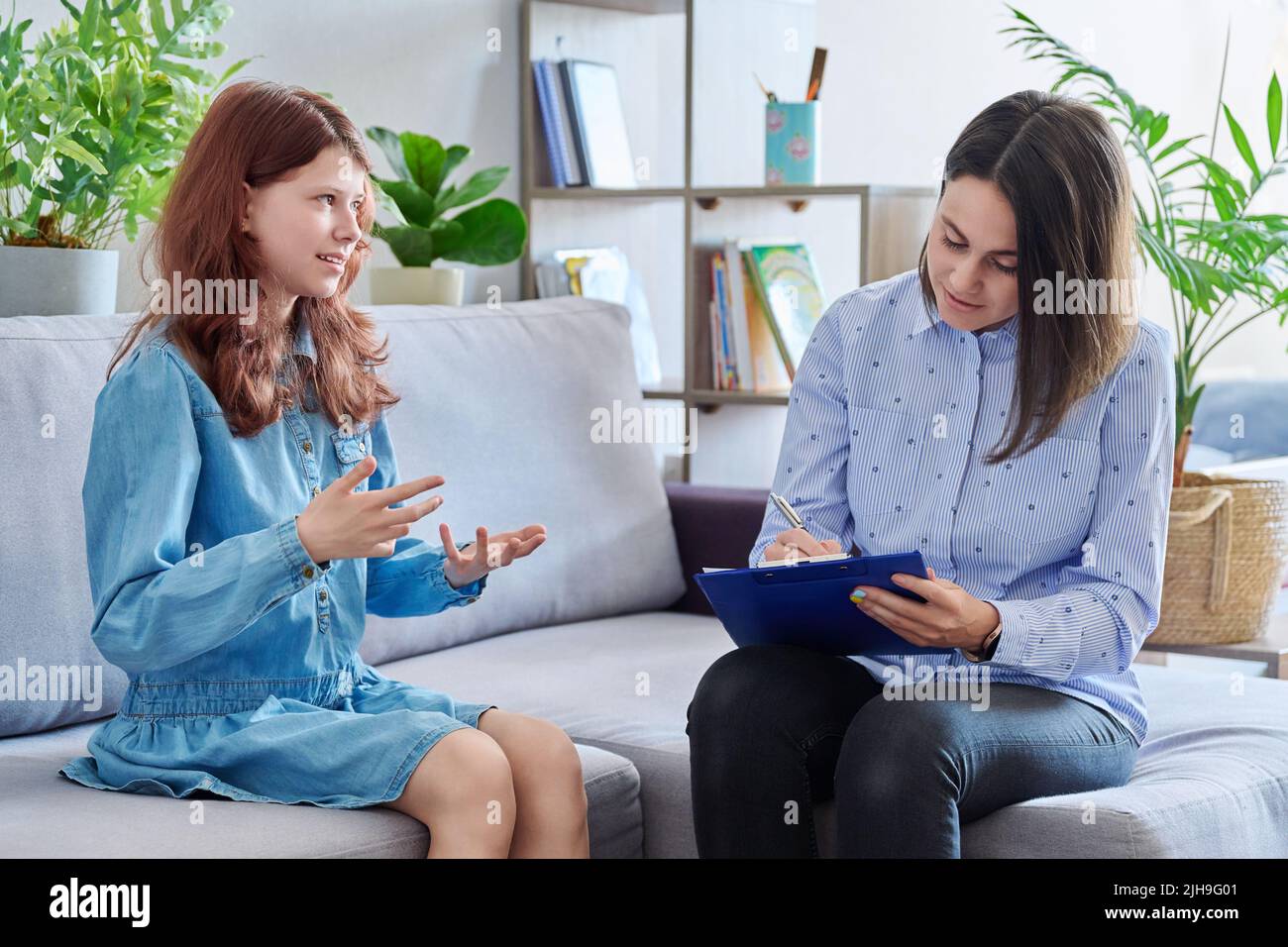 Female professional child psychologist working with preteen girl in ...