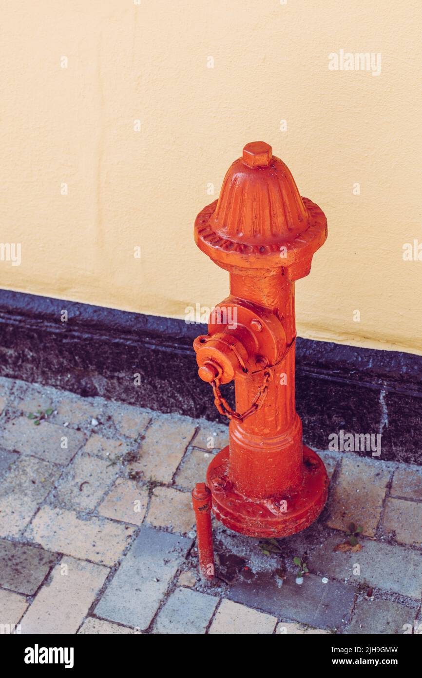 An orange traditional fire hydrant on a side walk Stock Photo - Alamy