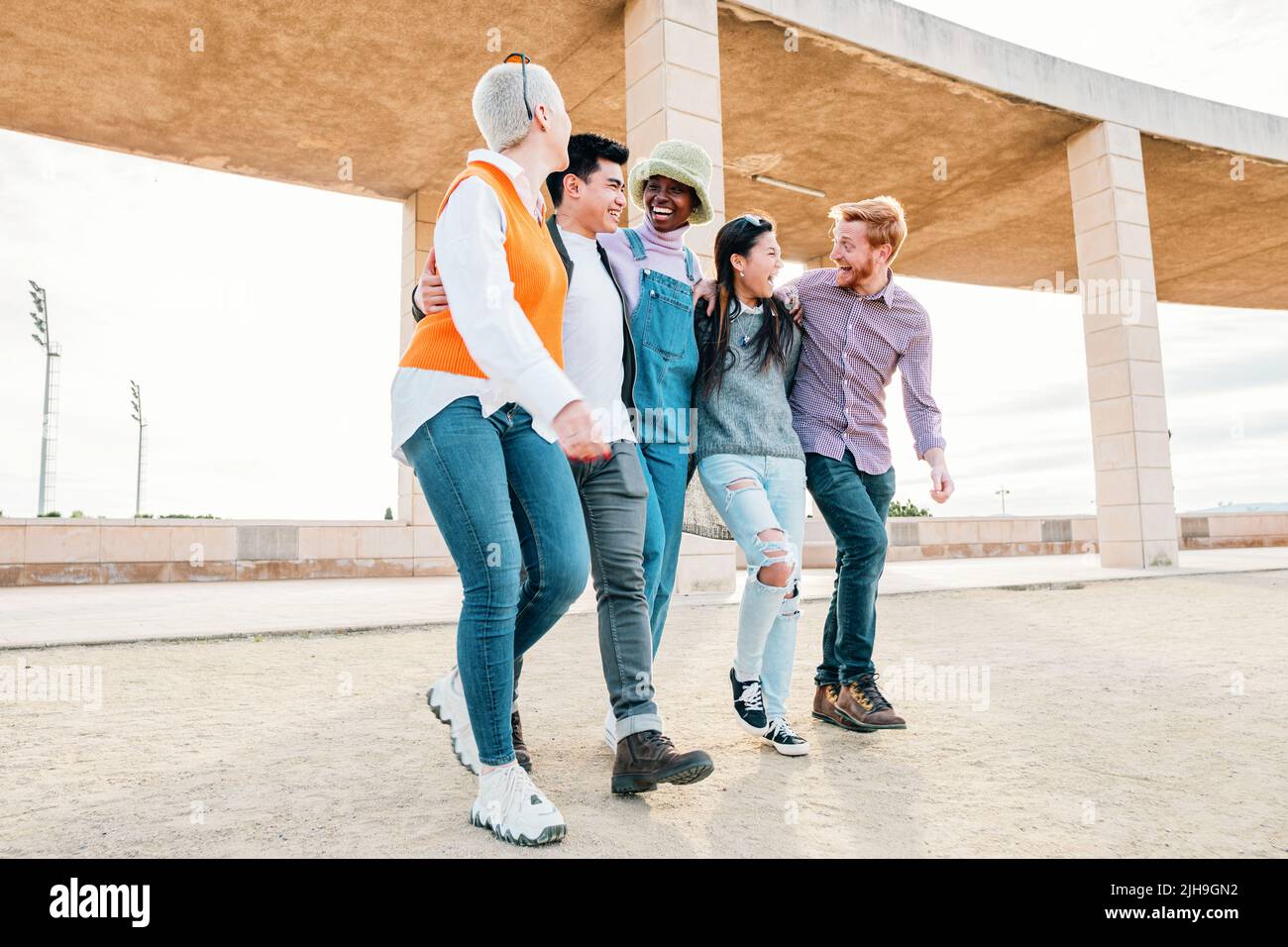 Group of friends having fun together and walking on the street in a ...