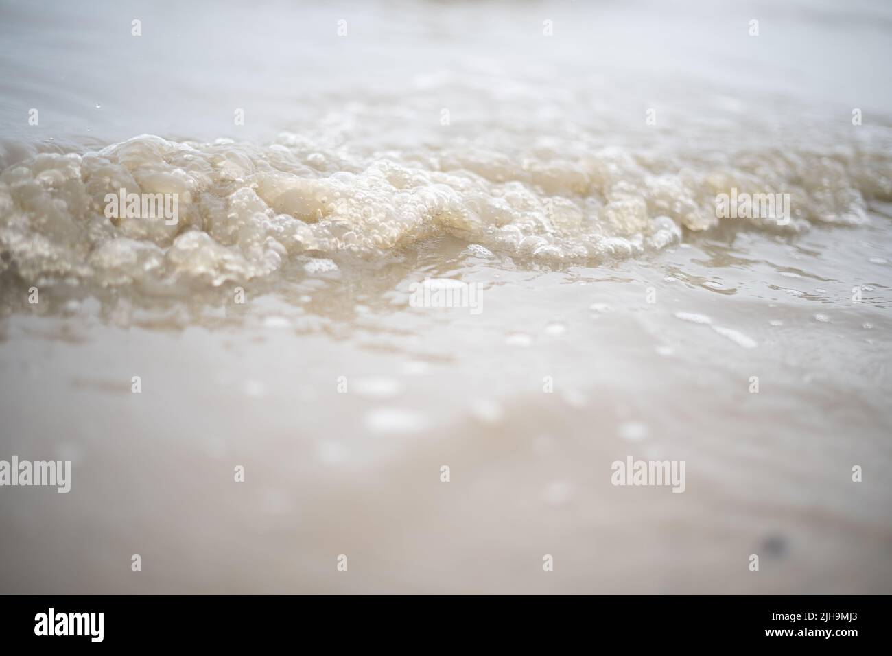 The brown colored waves in the sea water Stock Photo - Alamy