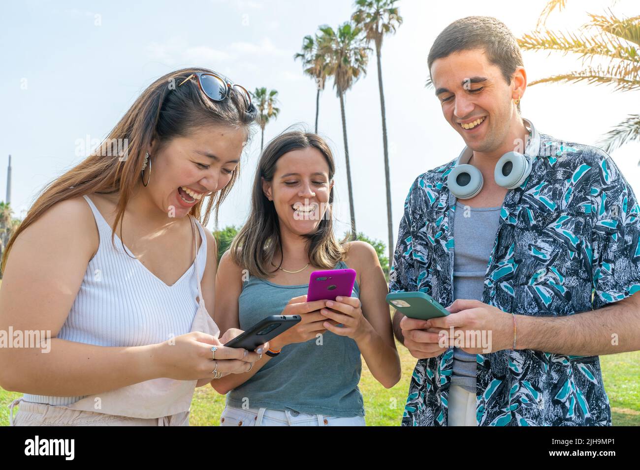 Multicultural group of trendy young friends having fun using ...