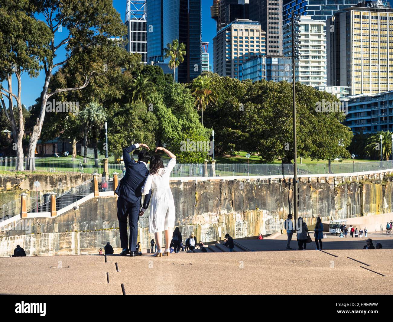 Tourists posing on the steps of the Sydney Opera House looking across ...