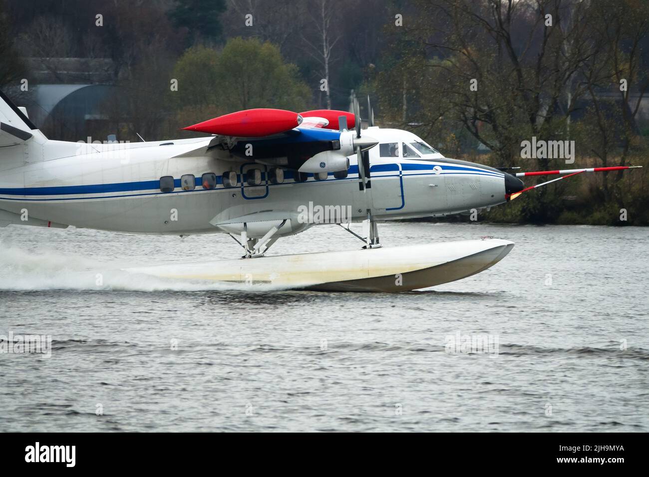 The Twin-engine seaplane a seaplane rises from water, from the forest ...