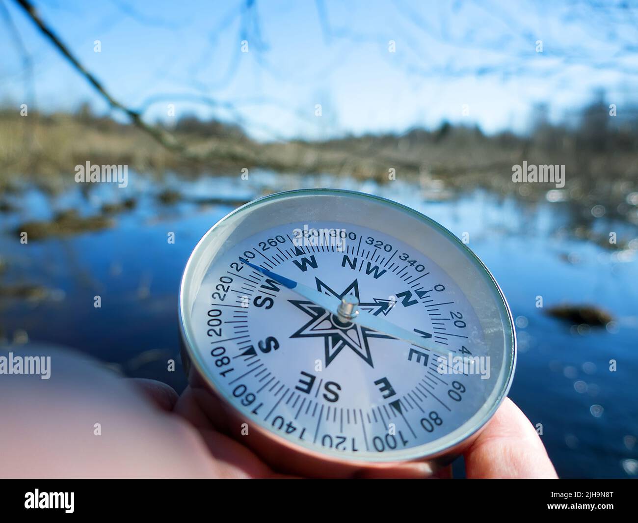 The northern swamp and a hiker hand with a compass. Traveling through ...