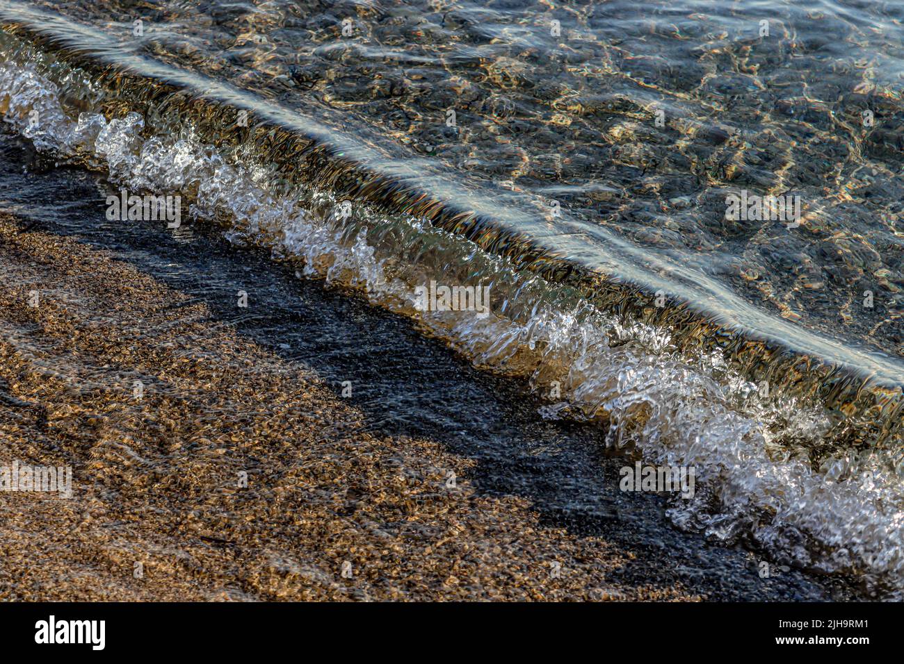 Sea waves breaking on the beach with sand and pebbles Stock Photo - Alamy
