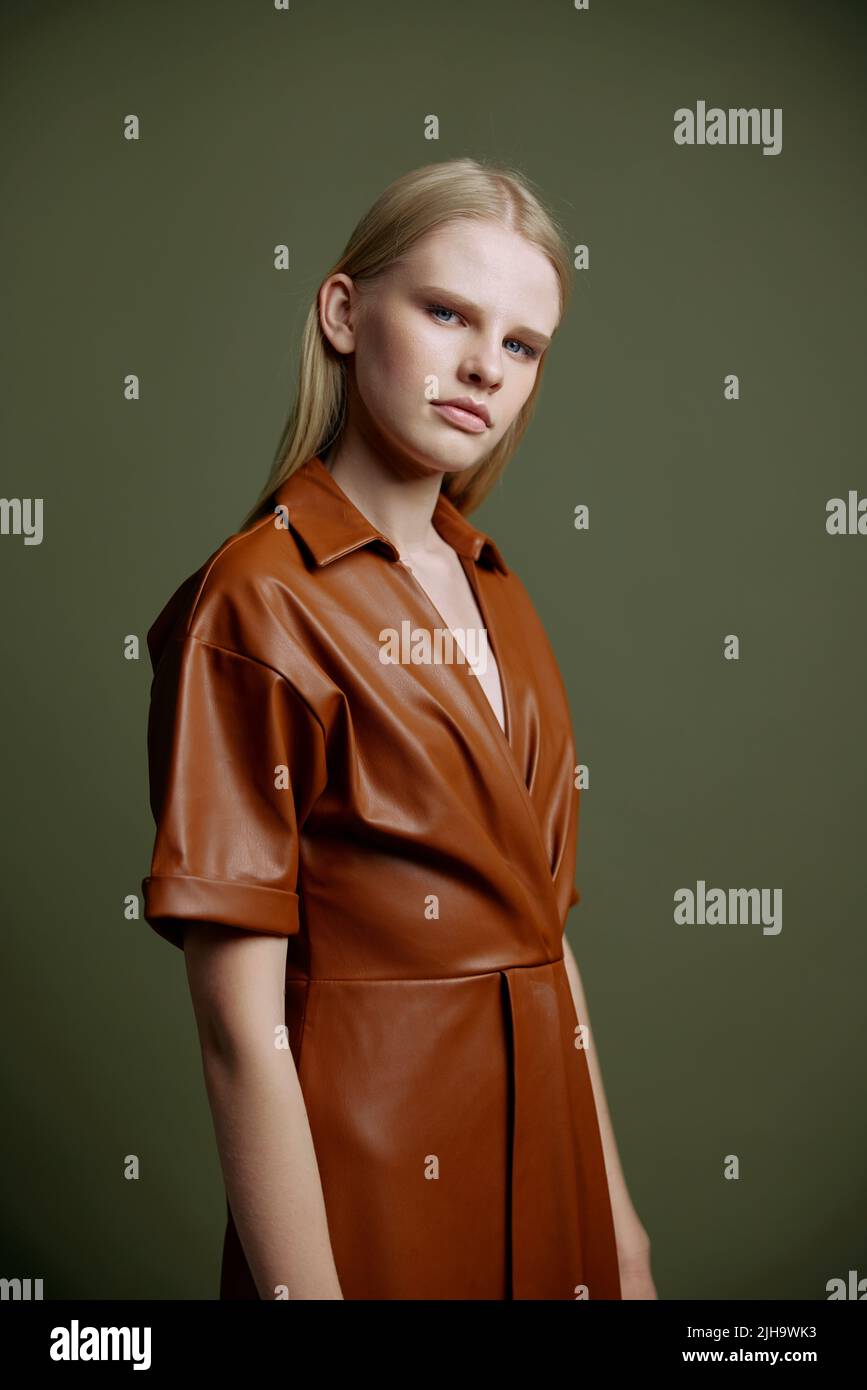 Self-confident fashionable blonde young model looking over her shoulder ...