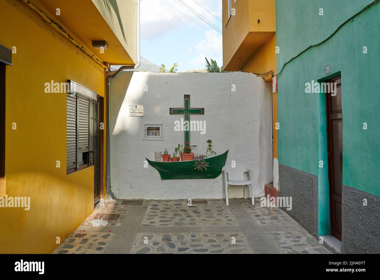 Historic colorful buildings with a white wall with a crucifix on it in ...