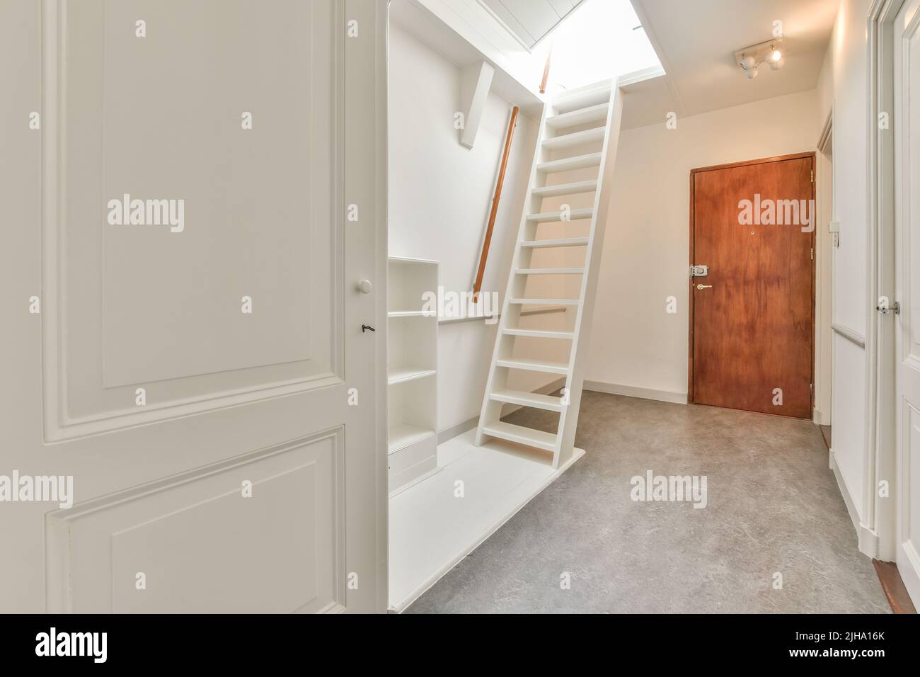 Light narrow hallway with many doors in white walls and over parquet ...