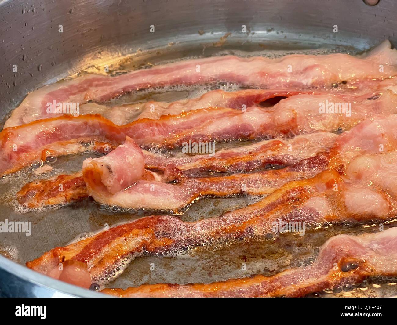 Bacon Sizzling in hot skillet Stock Photo - Alamy