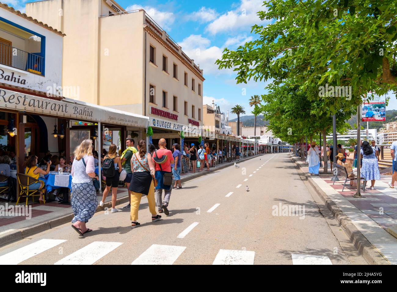 Tourists enjoy sidewalk cafes and shops at the seaside town of Tossa de ...