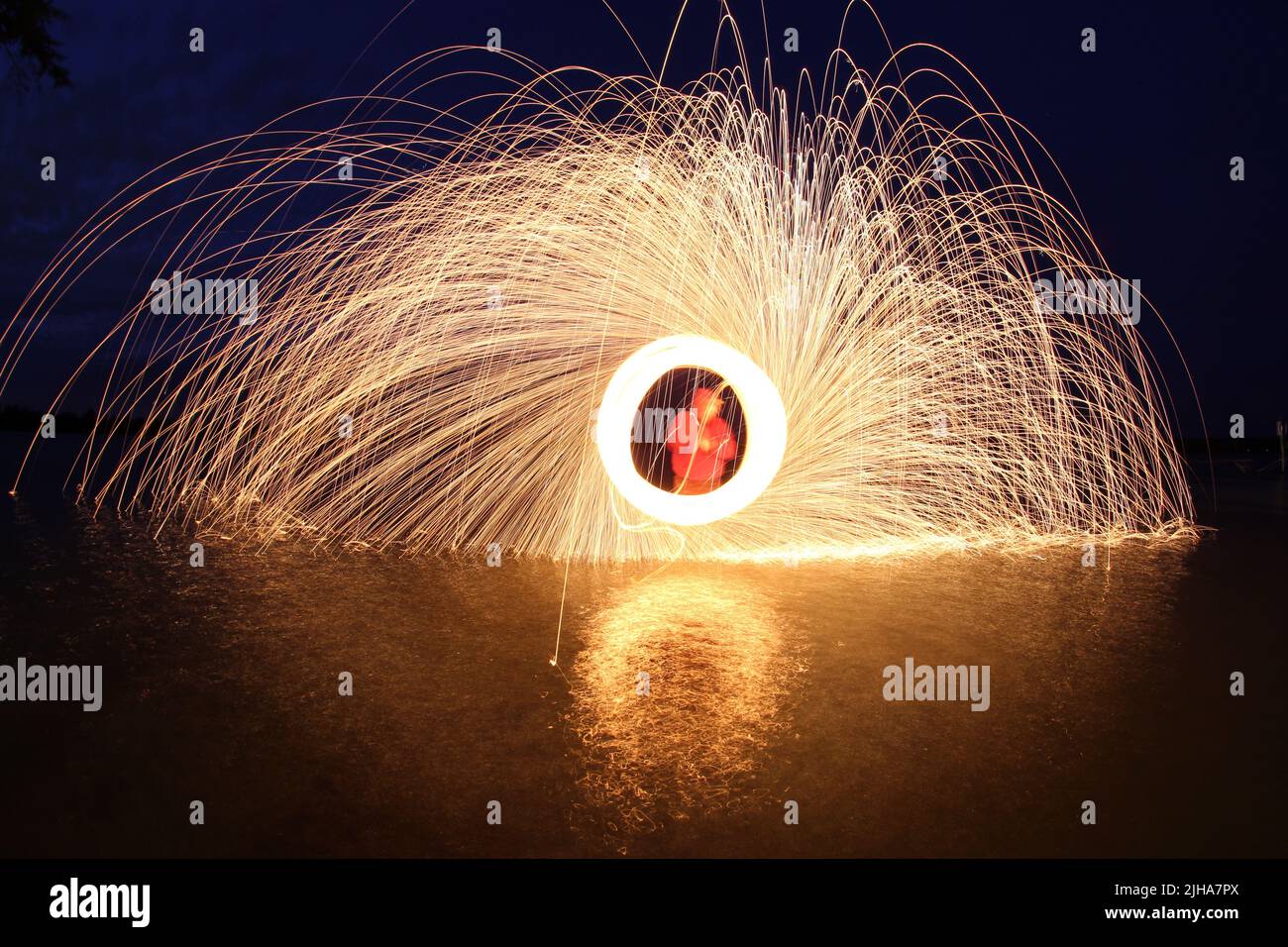 Spinning steel wool firework sparkling in the darkness Stock Photo - Alamy