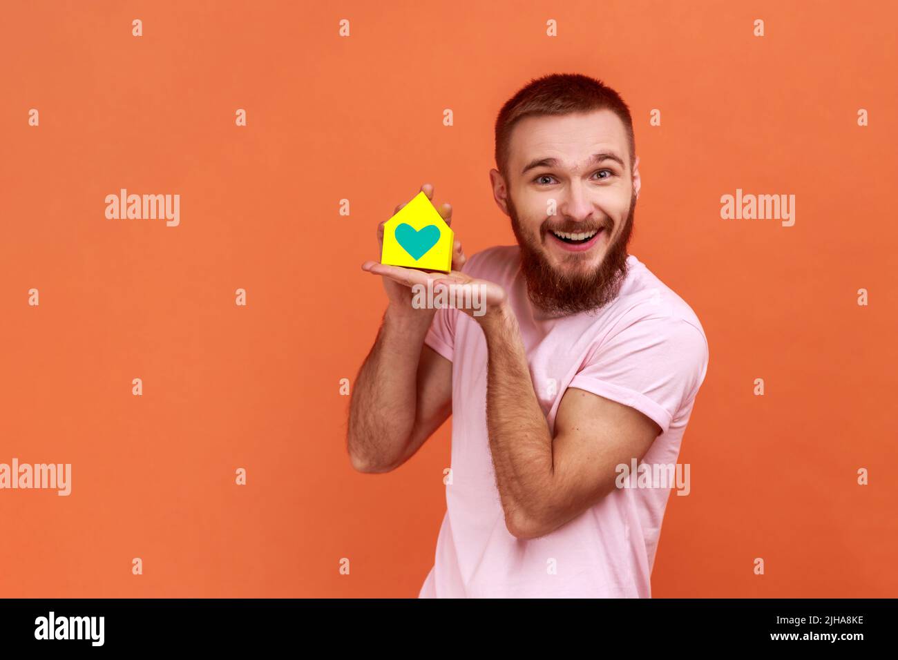 Portrait of bearded man holding in hands and showing paper model of ...
