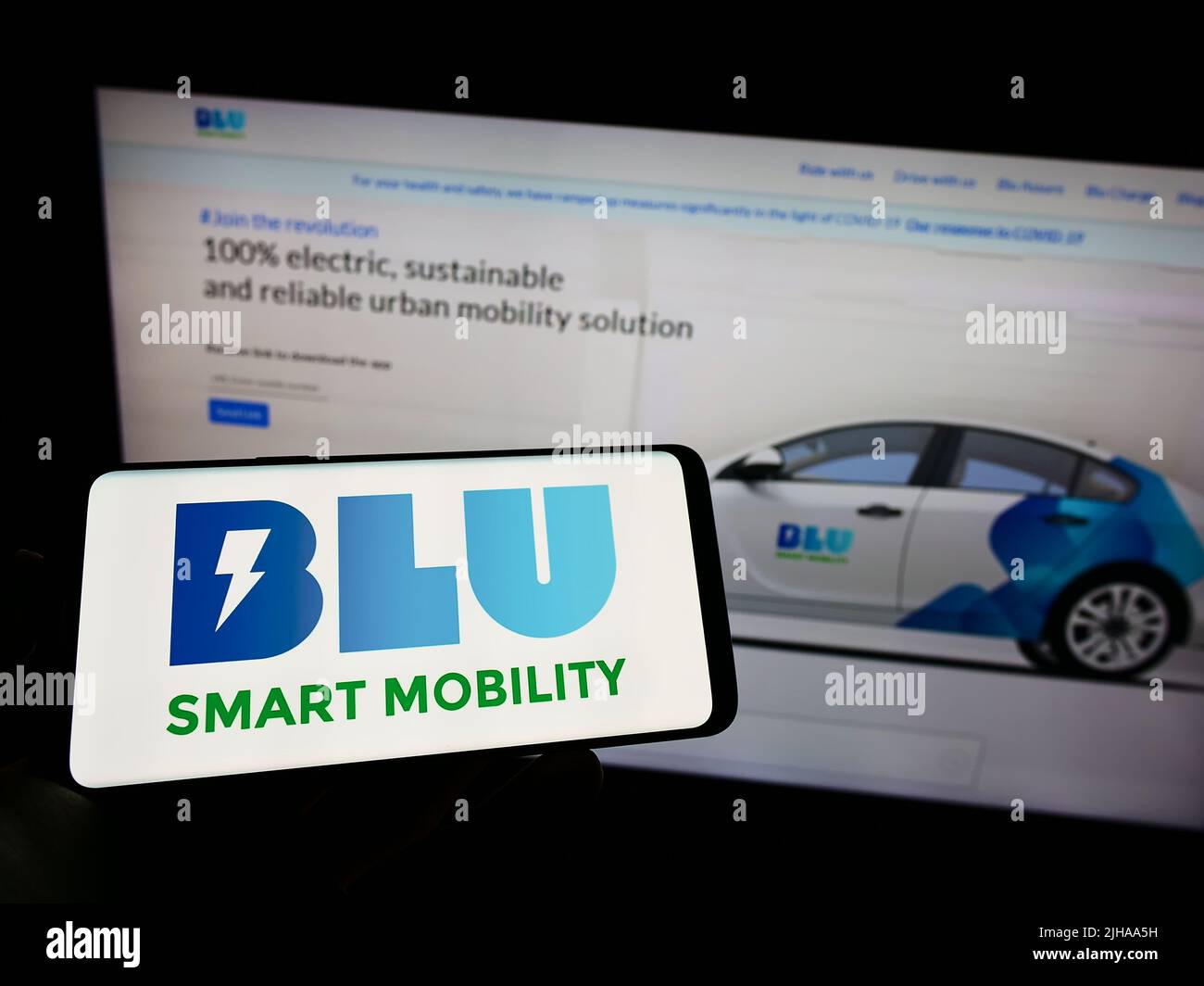 Person holding mobile phone with logo of Indian ride-sharing company ...