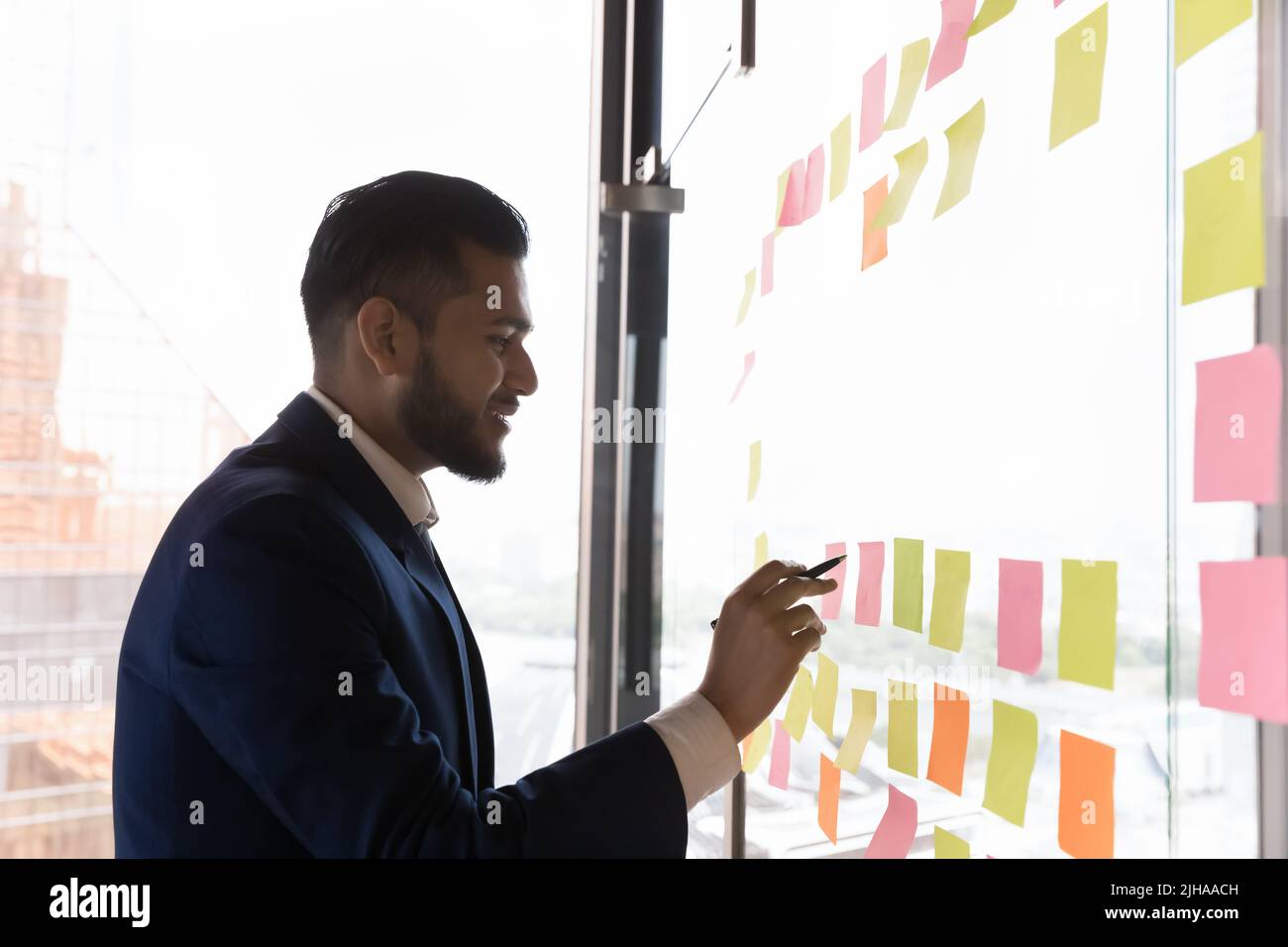 Happy busy Indian businessman making project schedule Stock Photo - Alamy