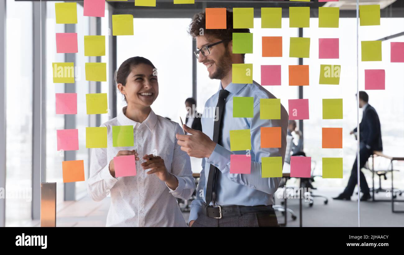 Happy multiethnic coworkers discussing successful project at colorful ...