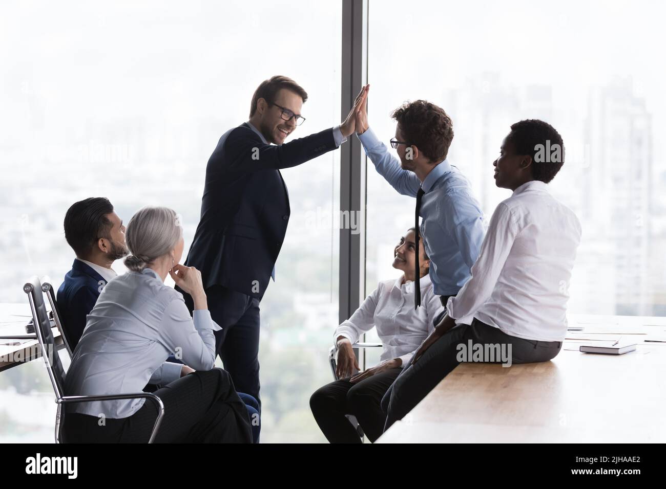 Happy coworkers clapping hands at team meeting, celebrating group ...