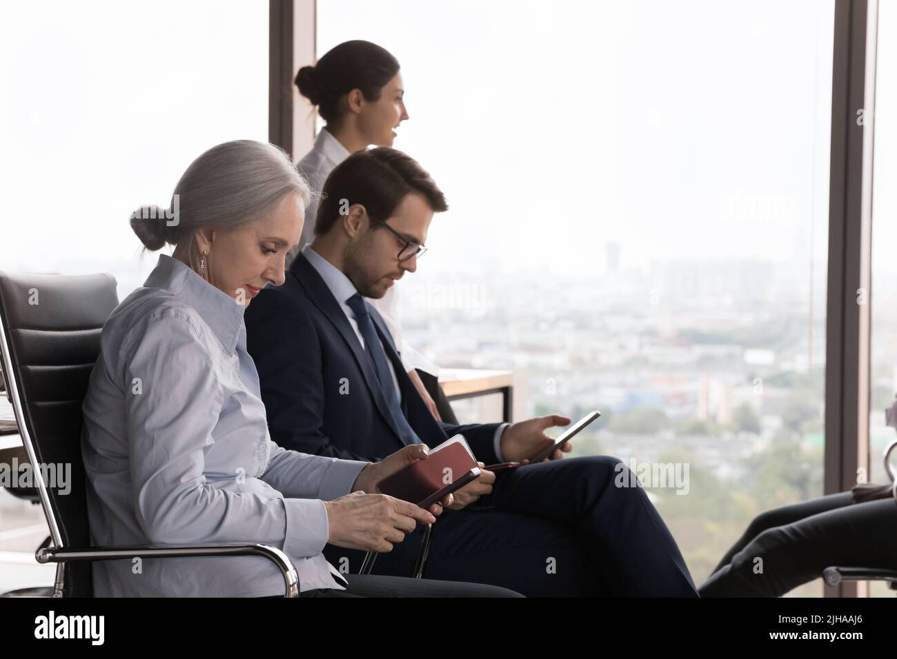 Serious diverse employees using work app on mobile phones Stock Photo ...