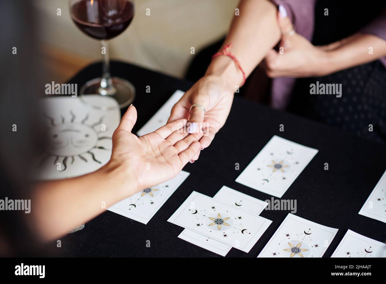 Fortune teller asking young woman to give her hand for palm reading ...