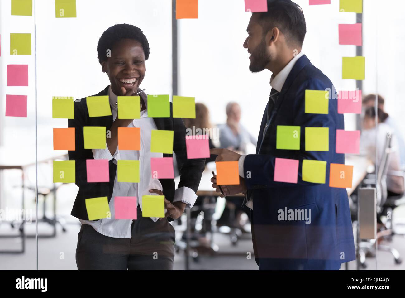 Cheerful diverse business team partners talking at glass board Stock ...