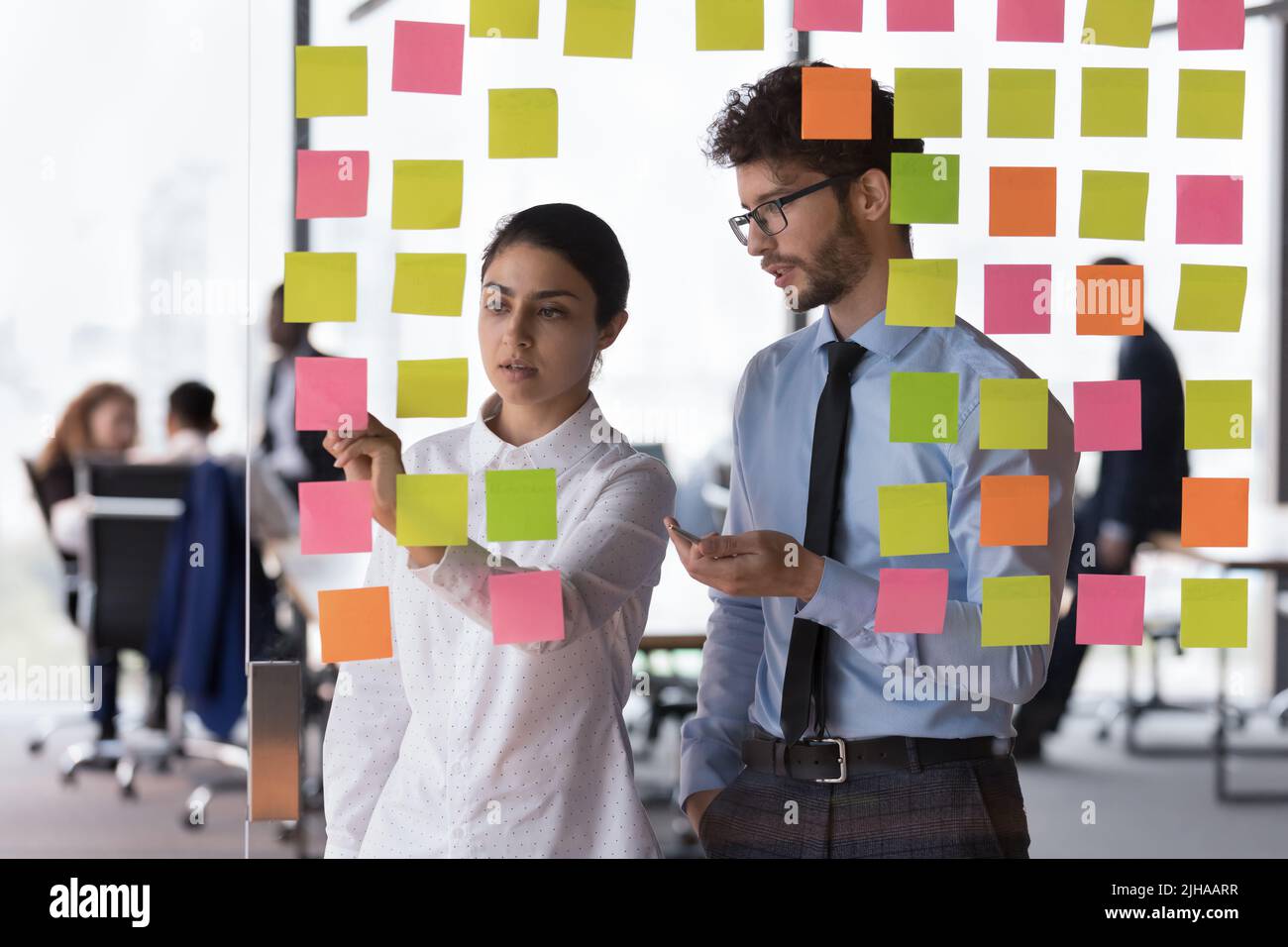 Diverse millennial employees, coworkers discussing project schedule ...
