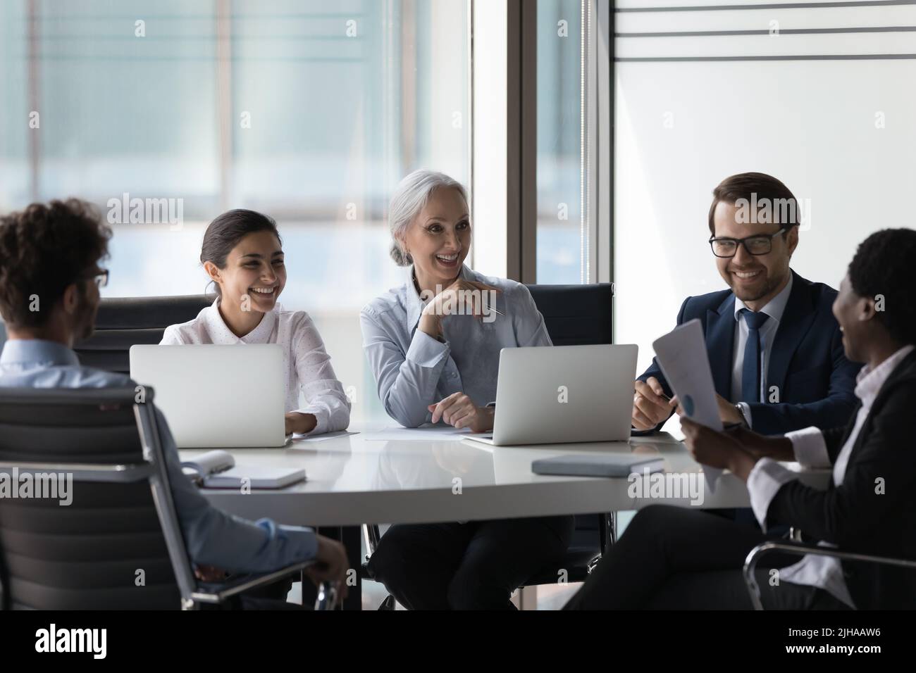 Happy different aged business team negotiating in meeting room Stock ...